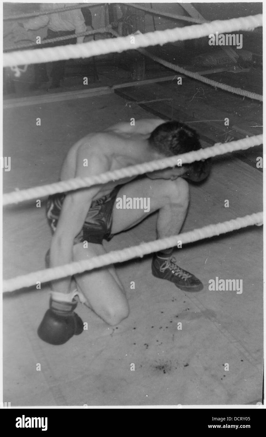 A boxer is seen kneeling during a fight, possibly recovering from a ...