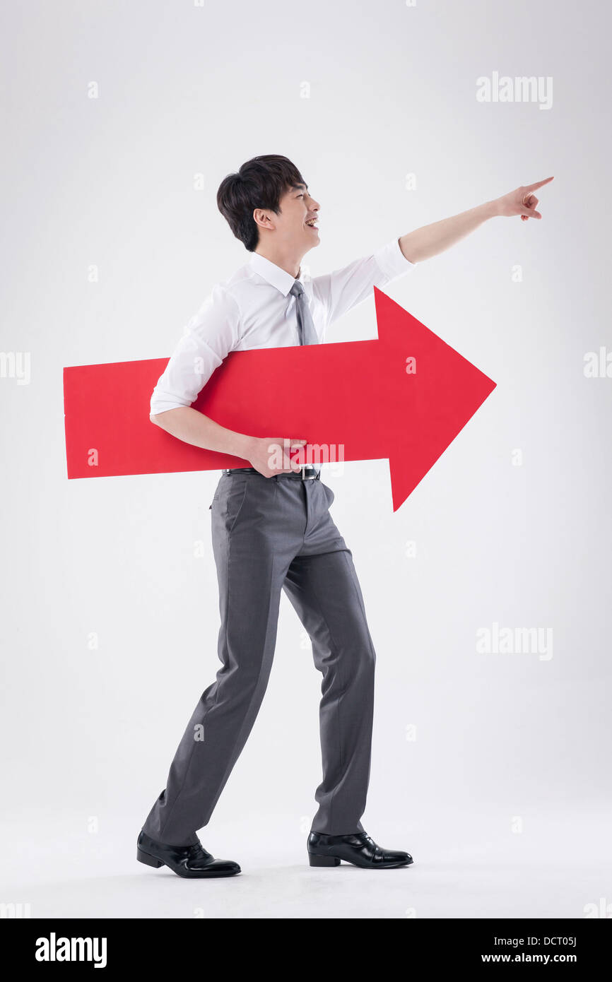 a business man holding an arrow Stock Photo - Alamy