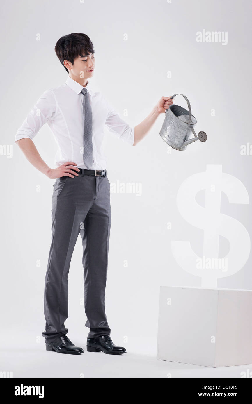 a business man next to a dollar sign Stock Photo - Alamy