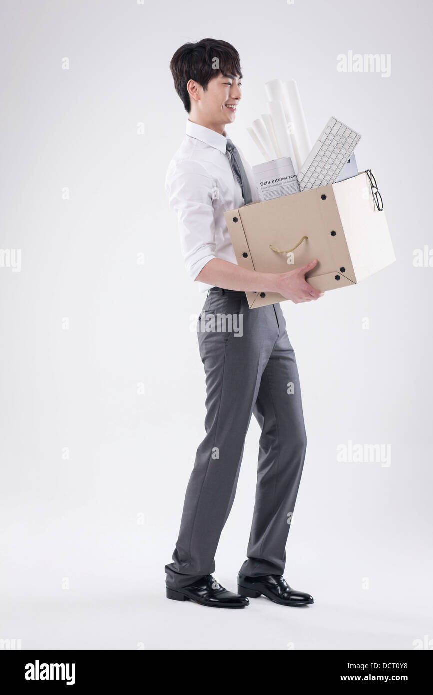 a business man carrying a box of stuff Stock Photo - Alamy