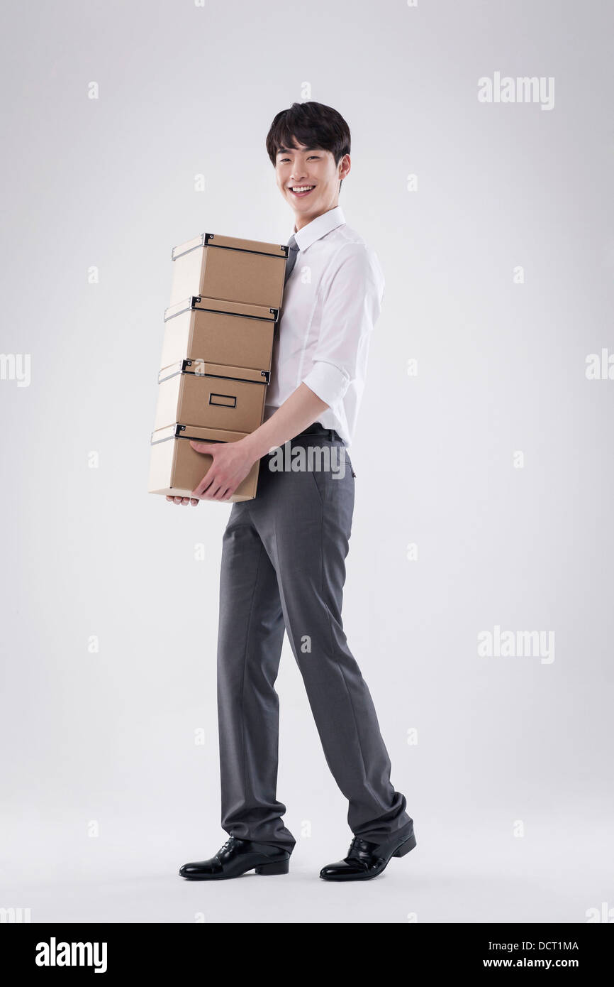 a business man carrying a pile of boxes Stock Photo - Alamy