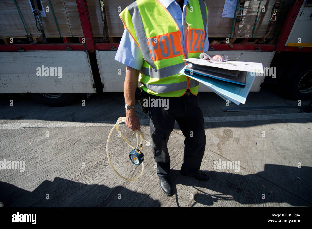 A policeman stands next to a truck during a spotcheck of commercial ...