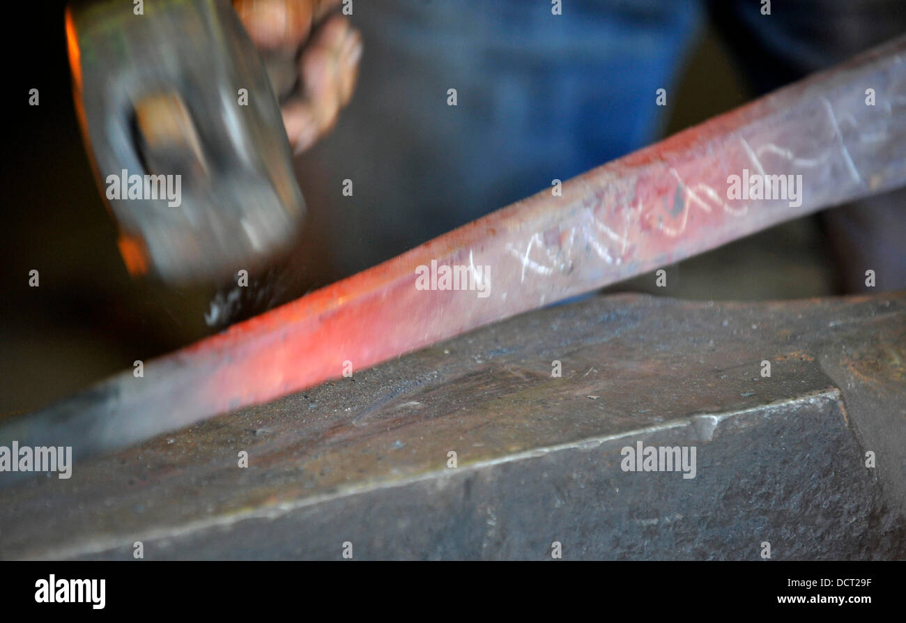 Five forgers from Israel work on metal sculpture of a bird during Forge ...