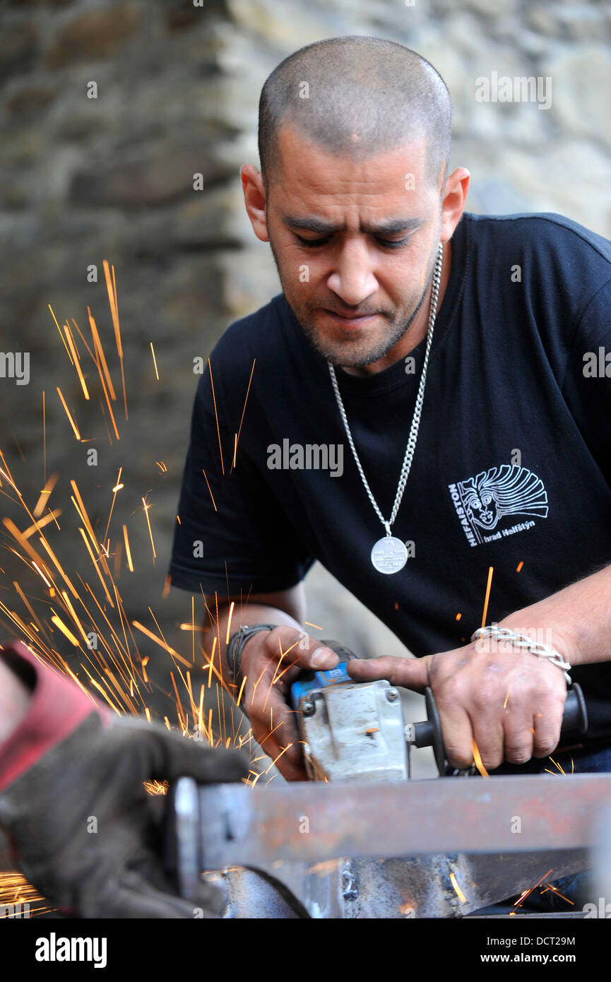Five forgers from Israel work on metal sculpture of a bird during Forge ...