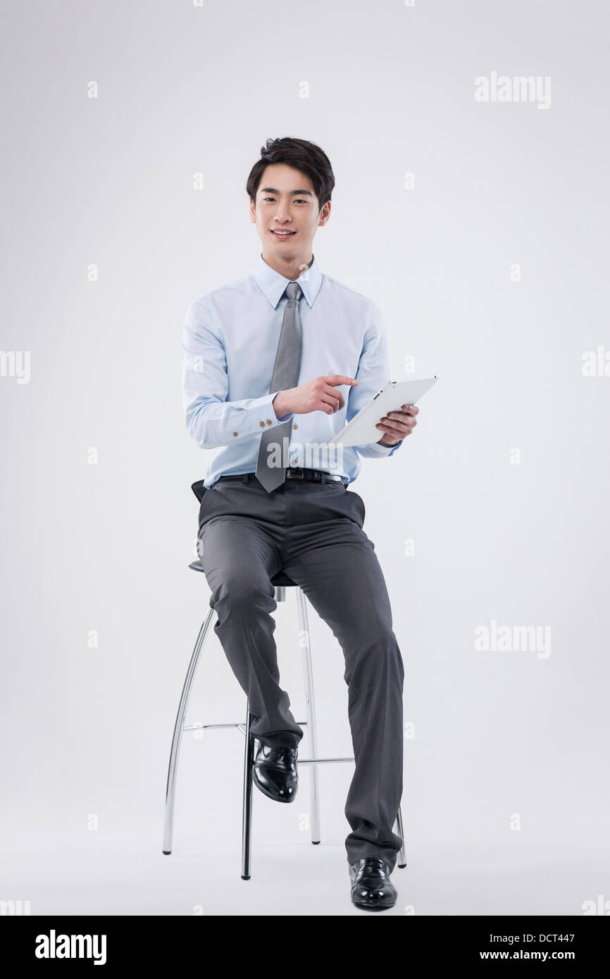 a business man sitting on a chair Stock Photo - Alamy