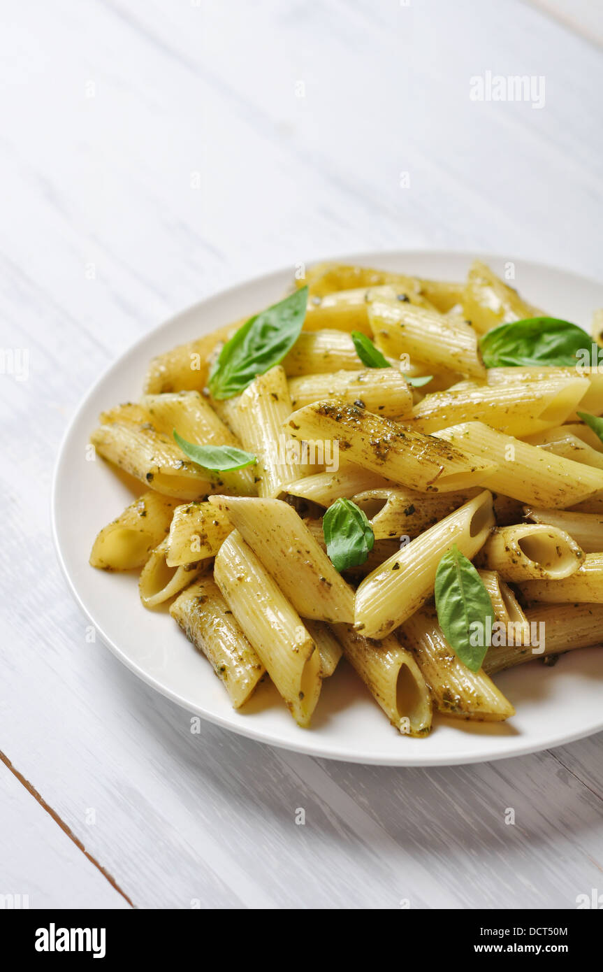 Penne pasta with pesto sauce and basil on white plate Stock Photo - Alamy