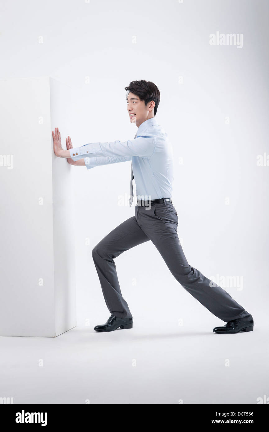 a business man pushing a block Stock Photo - Alamy
