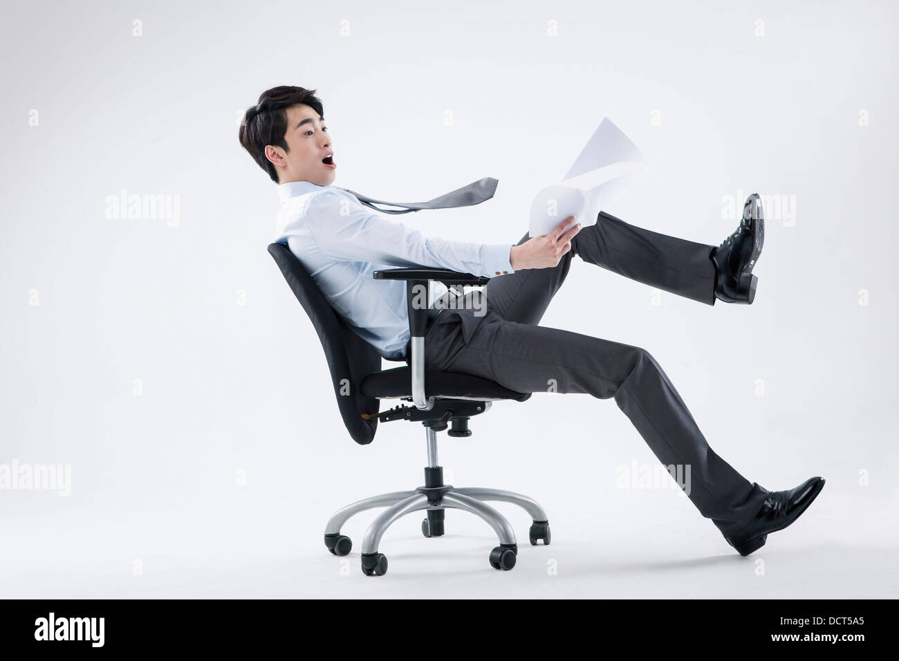 a business man playing with a chair Stock Photo - Alamy