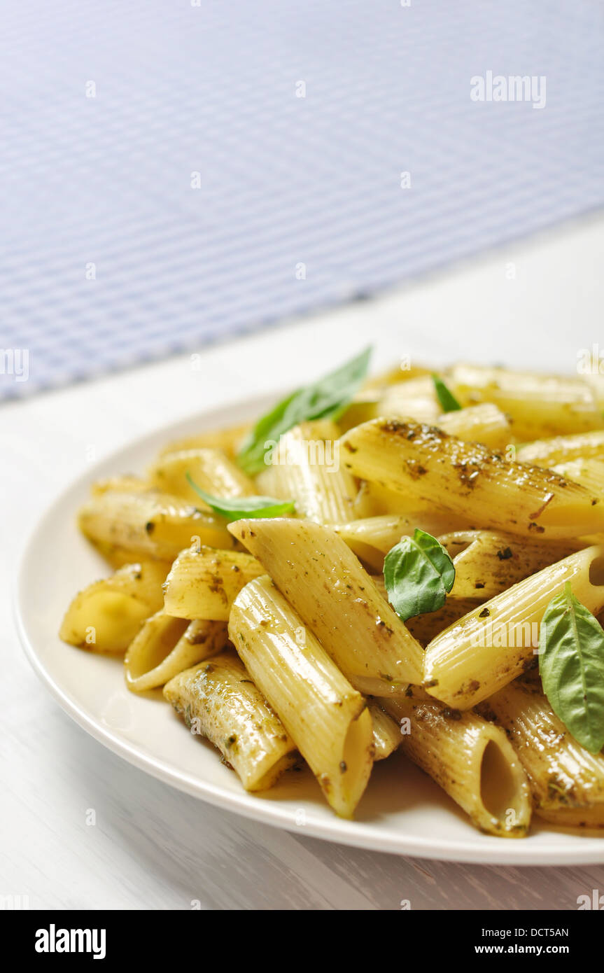 Penne pasta with pesto sauce and basil on white plate Stock Photo - Alamy