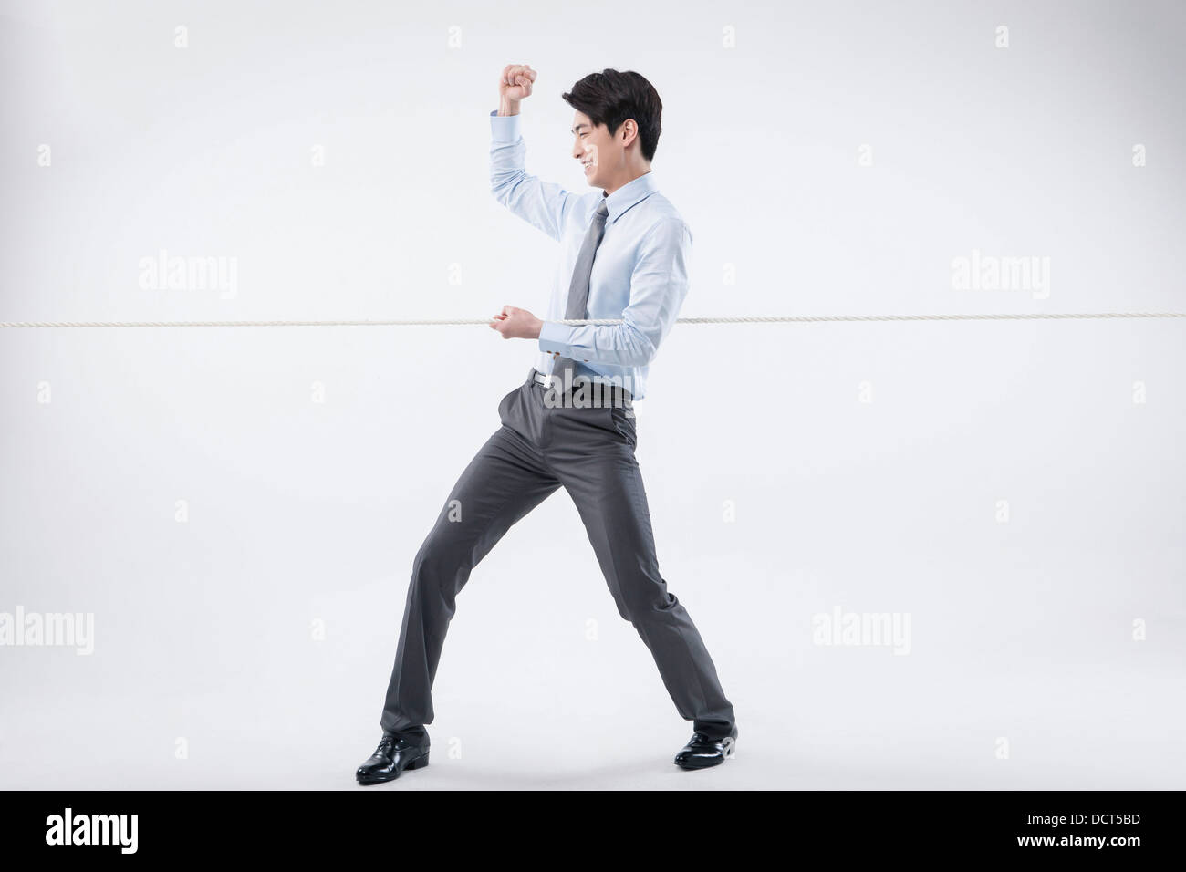 a business man pulling a wire Stock Photo - Alamy