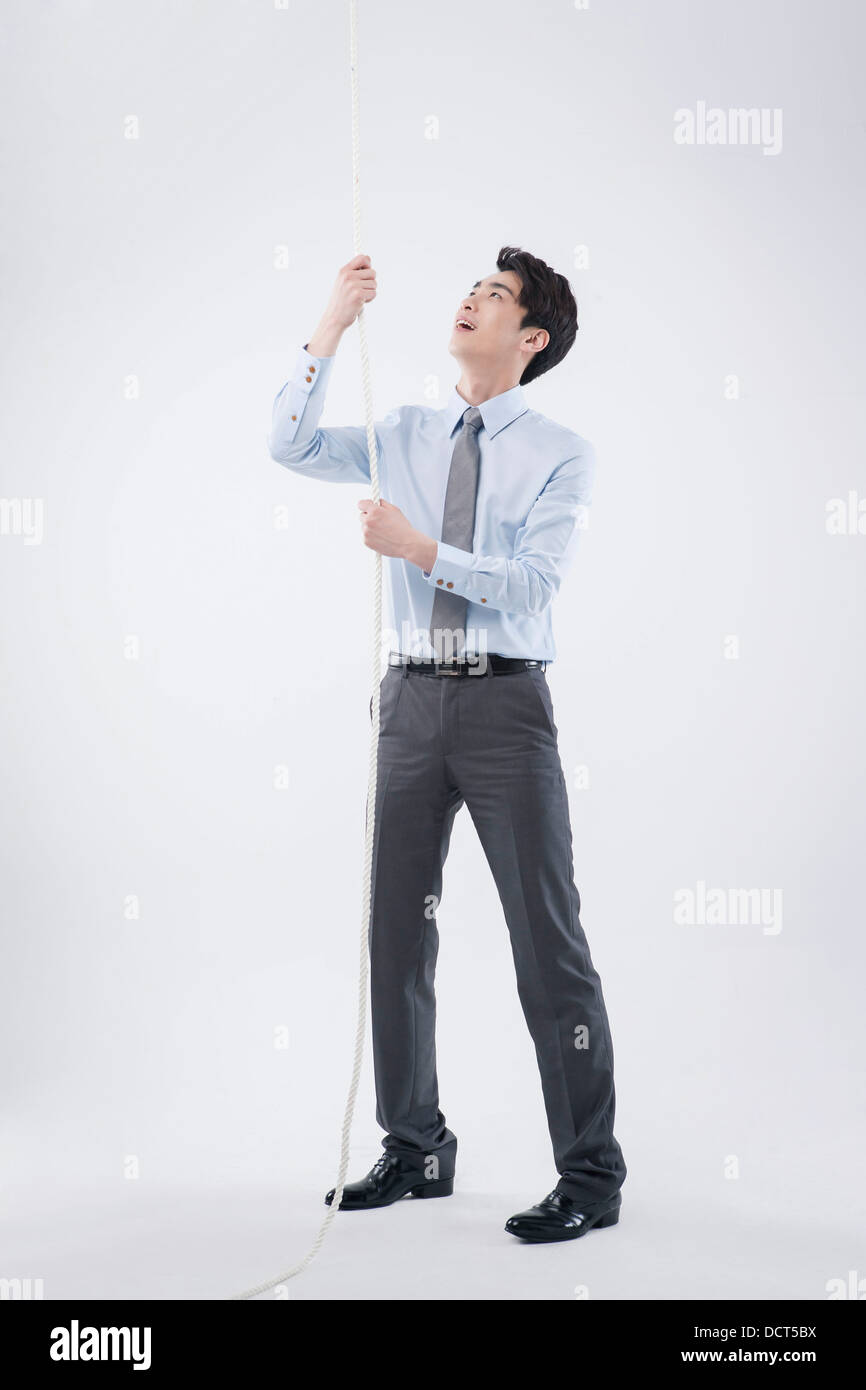 a business man pulling a wire Stock Photo - Alamy