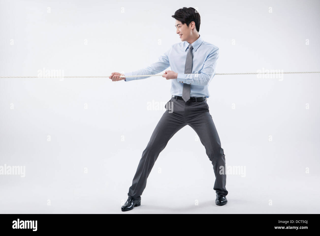 a business man pulling a wire Stock Photo - Alamy