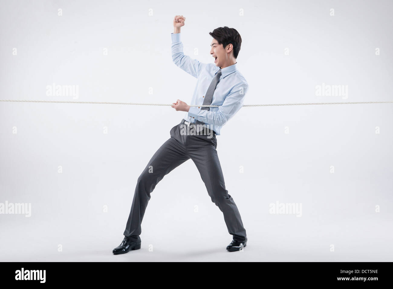 a business man pulling a wire Stock Photo - Alamy