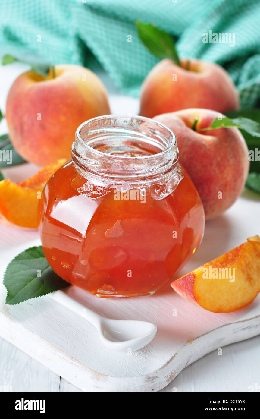 peach jam in glass jar on white wooden background Stock Photo - Alamy