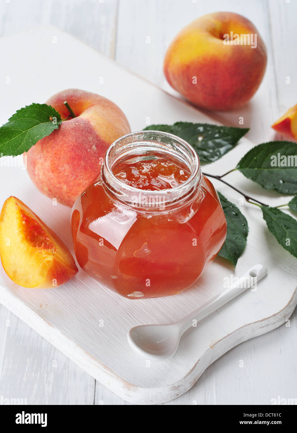 peach jam in glass jar on white wooden background Stock Photo - Alamy