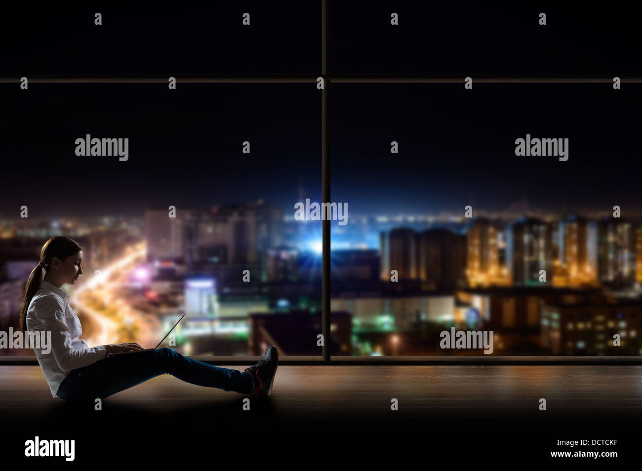 young woman sitting with a laptop by the window Stock Photo - Alamy