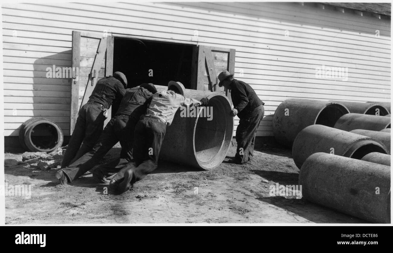 This image captures the installation of concrete culverts, a crucial ...