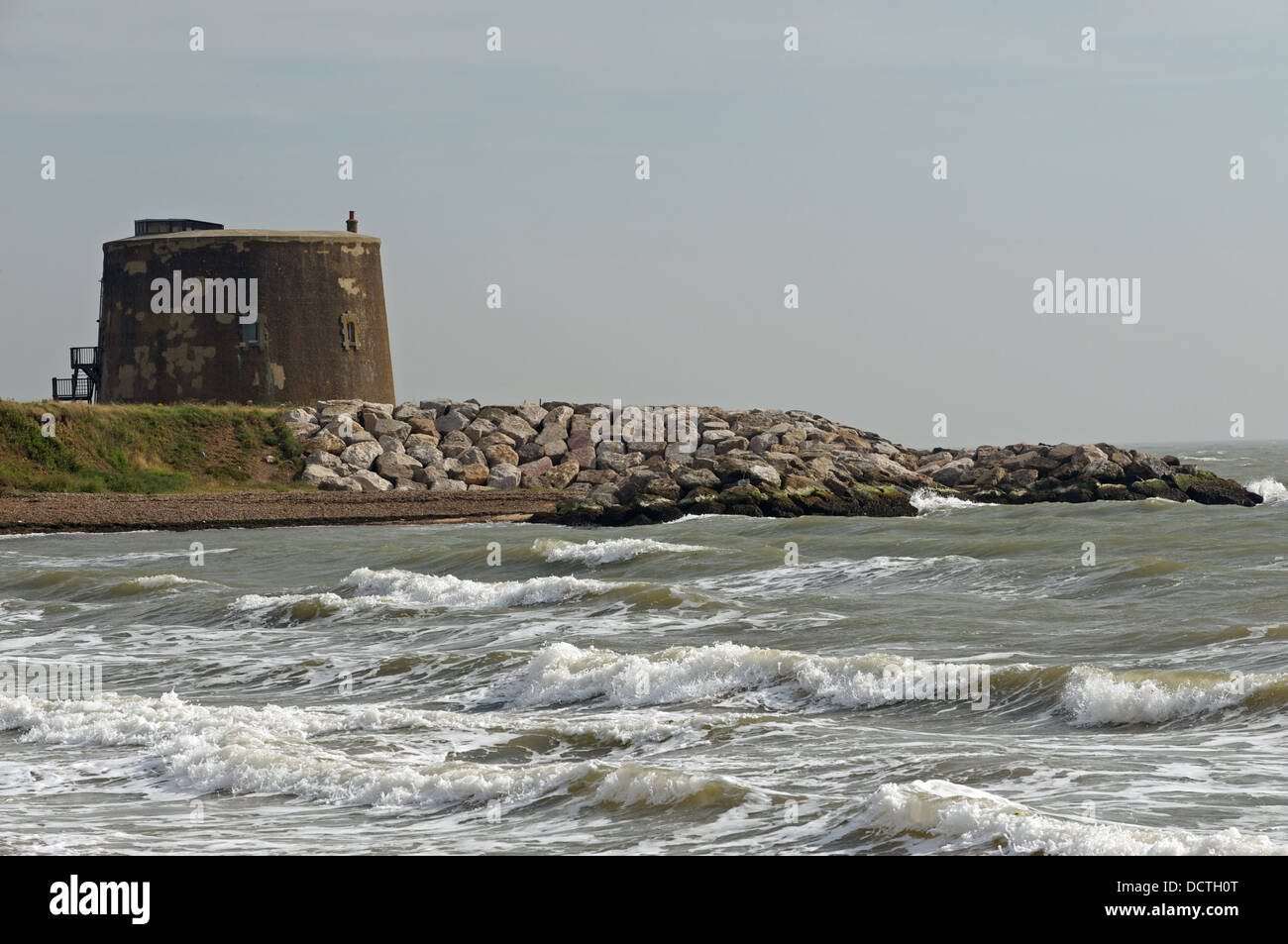 Rock armour (coastal defences) protecting a historic Martello Tower on ...