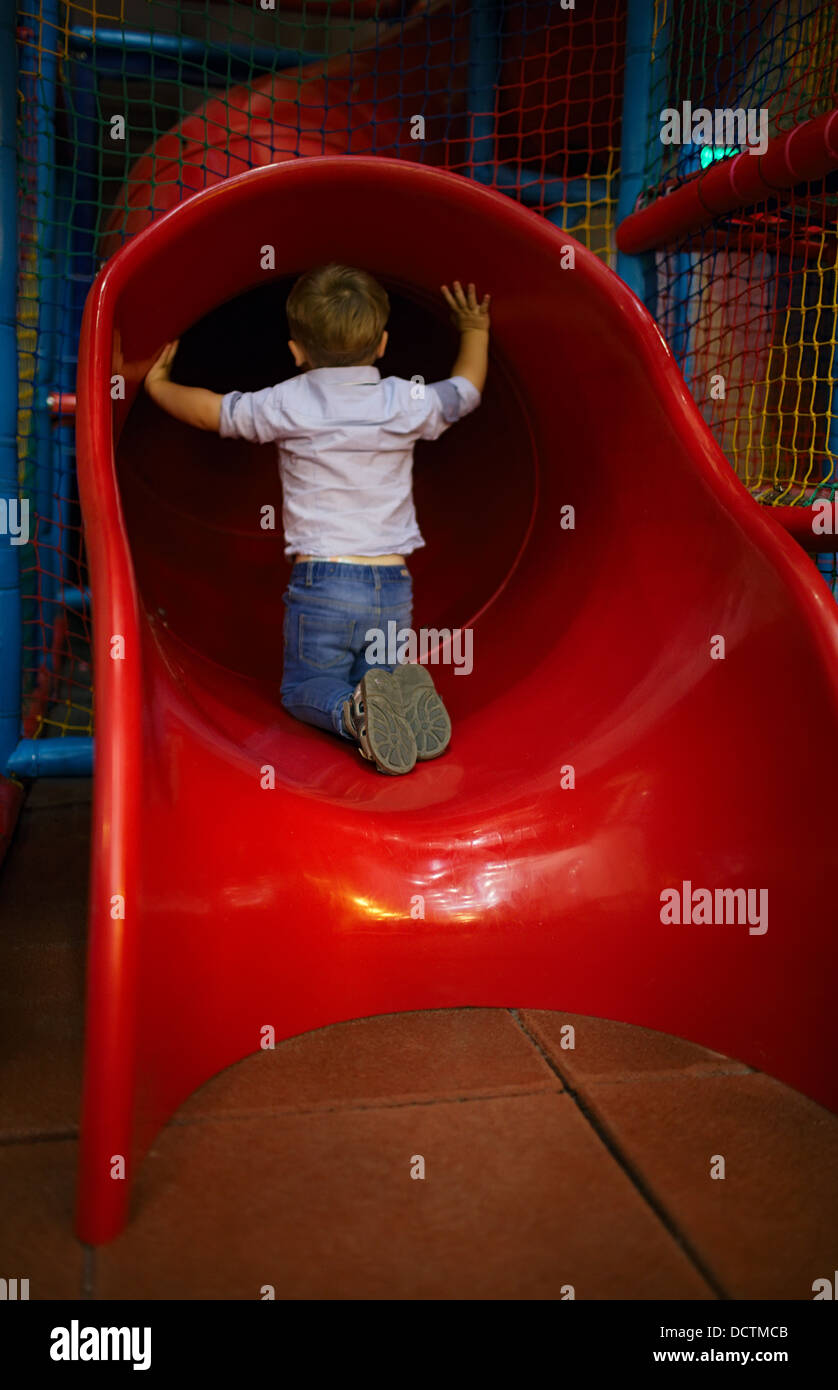 Boy is sitting at the slide hole Stock Photo - Alamy