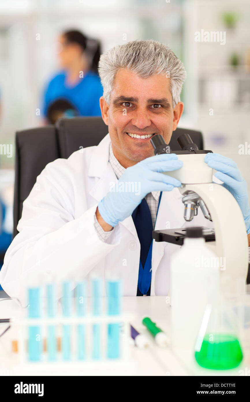 smiling senior scientist working on microscope in lab Stock Photo - Alamy