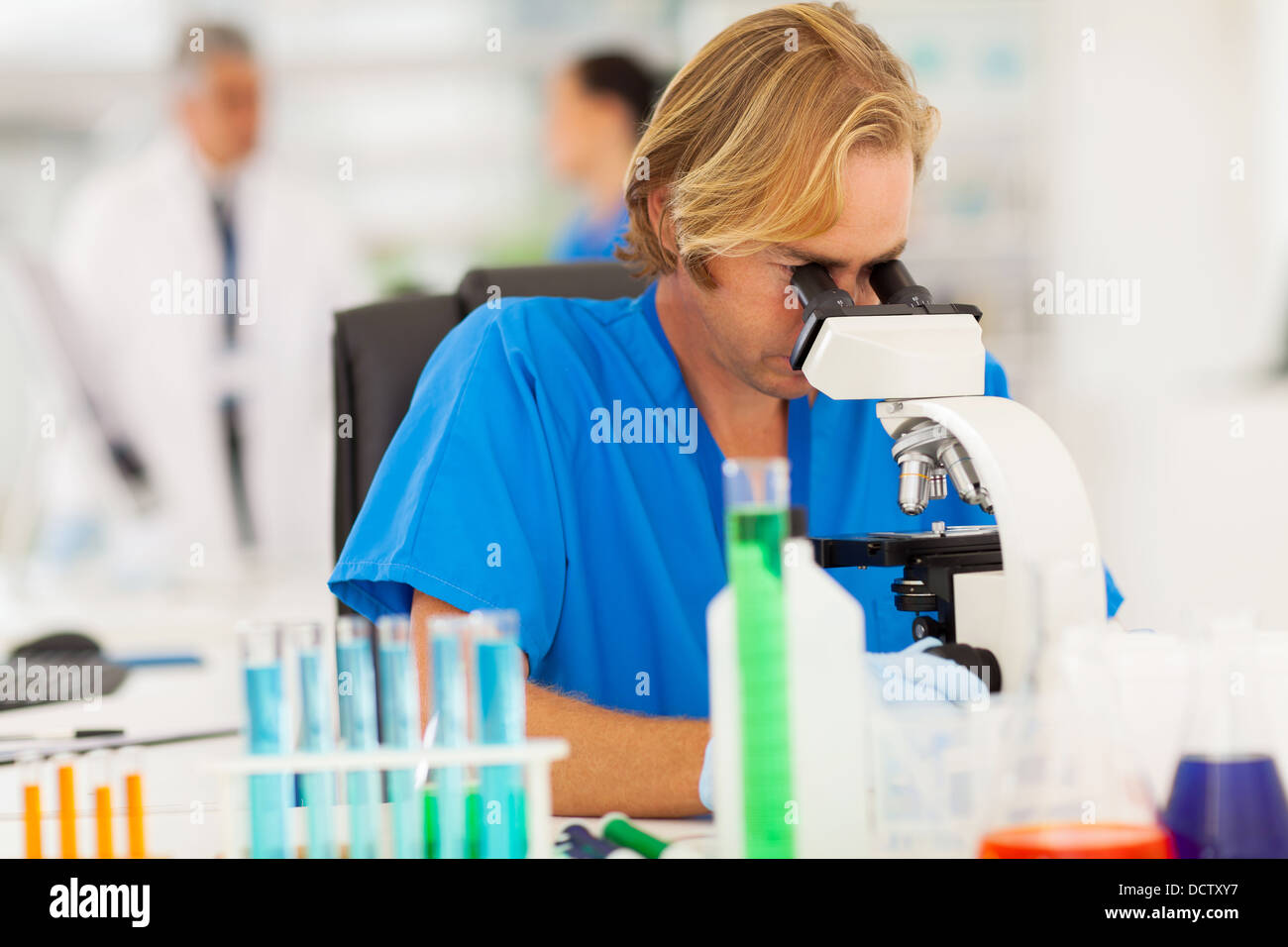 male scientist looking through microscope in the lab Stock Photo - Alamy
