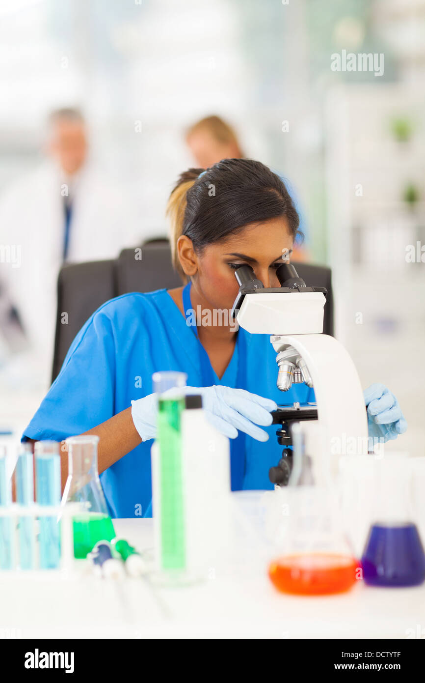 young Indian scientist looking through microscope at the lab Stock ...