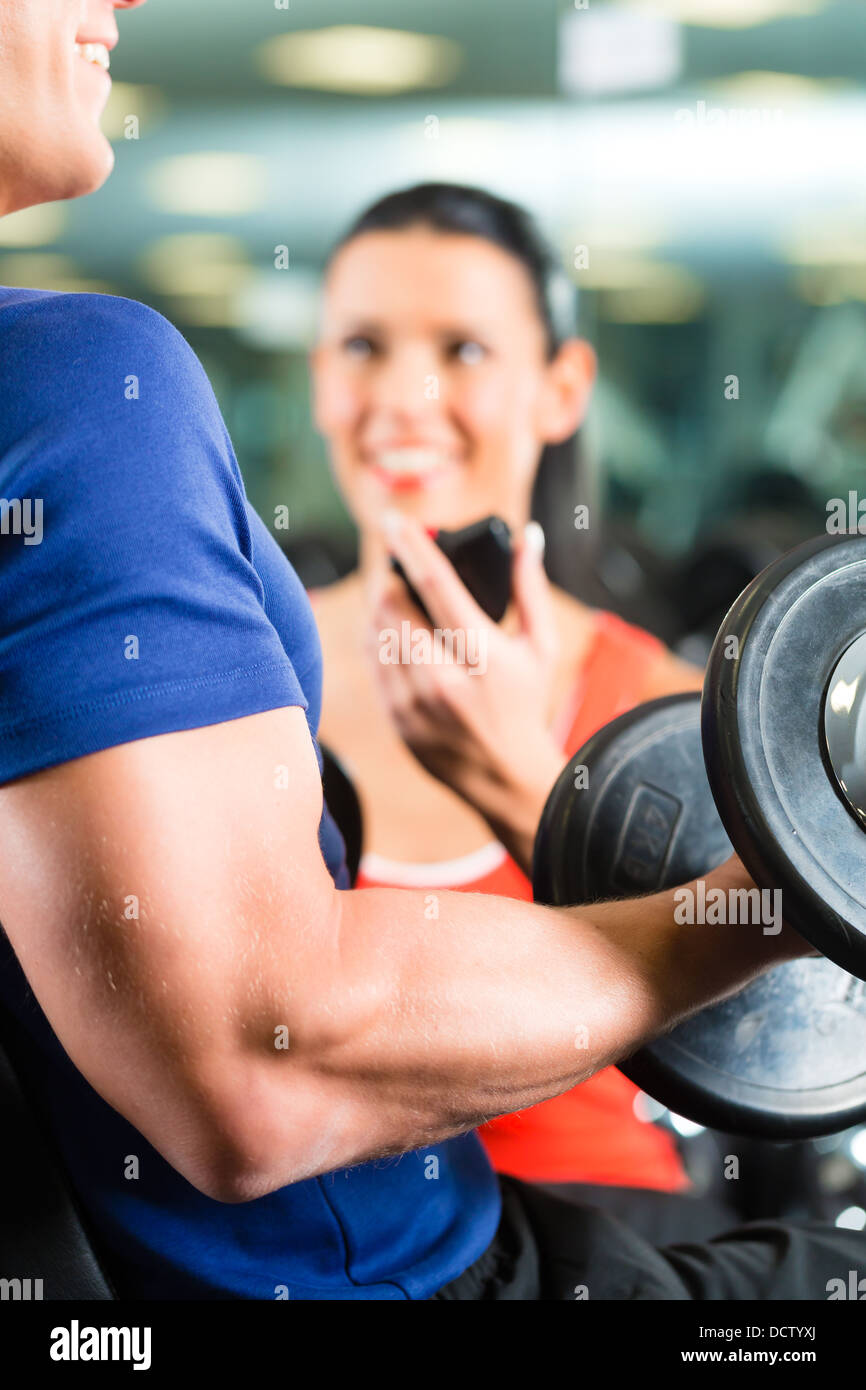 Man or Bodybuilder with his personal fitness trainer in the gym ...