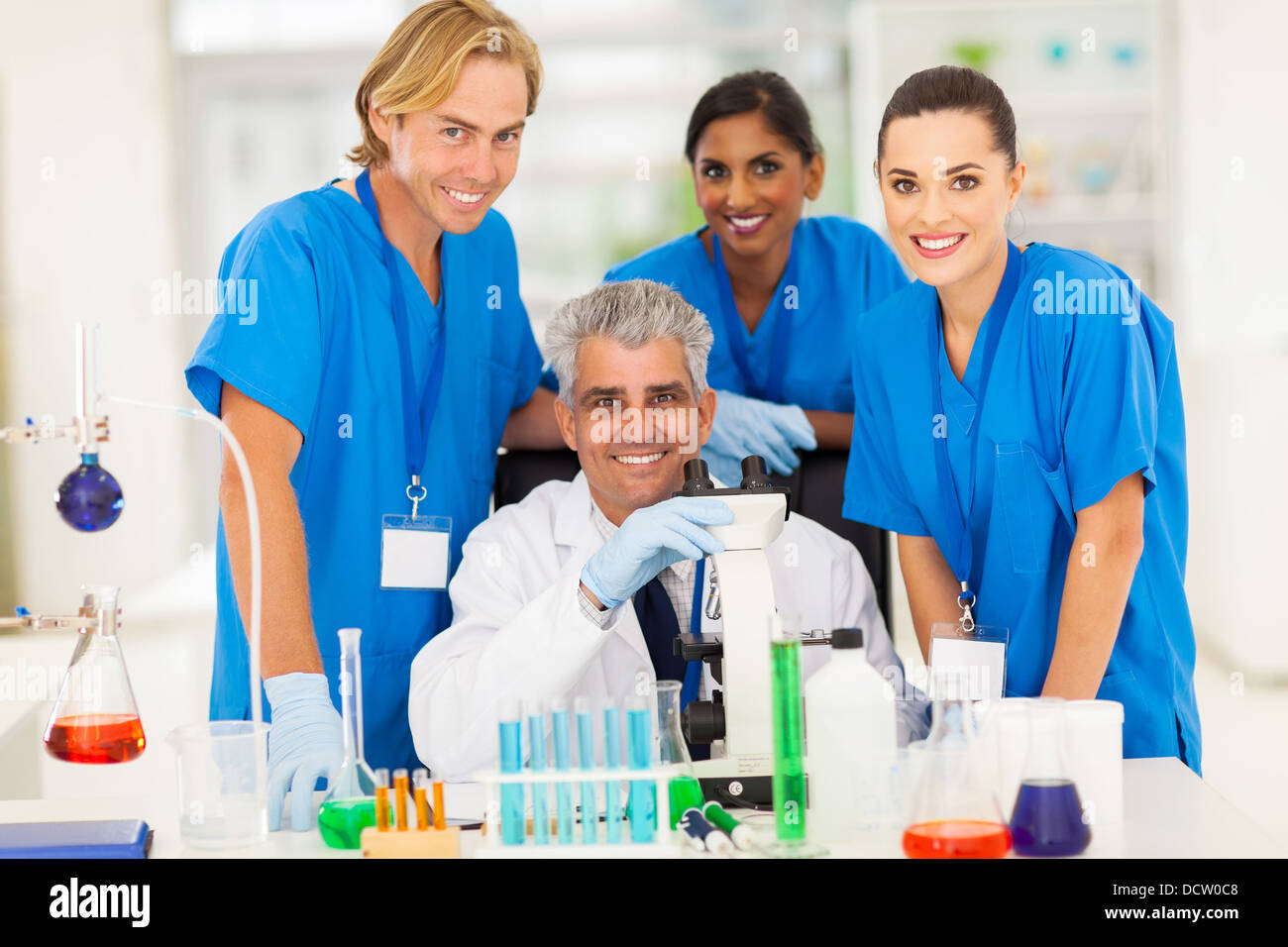 cheerful senior scientist with group of chemistry students in the lab ...