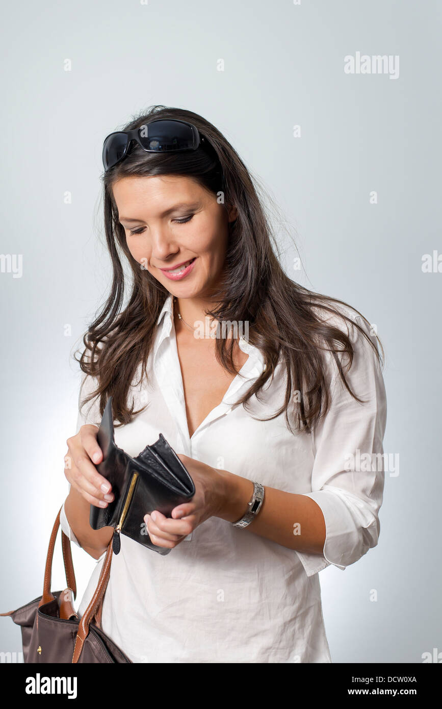 brunette woman looking in her purse Stock Photo - Alamy