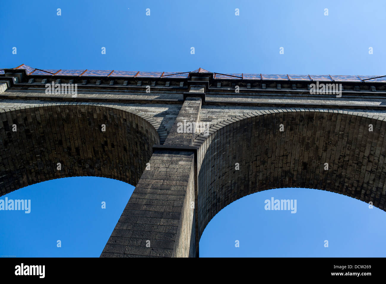 A stone archway stretches across the highway and the East River in ...