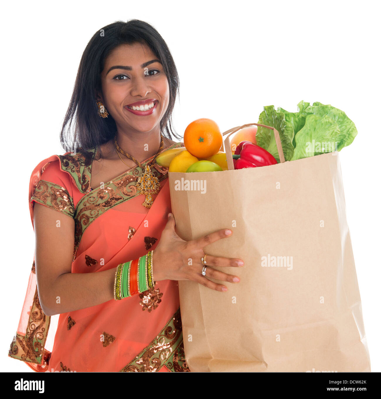 Happy grocery shopper. Portrait of beautiful traditional Indian woman in sari dress holding ...