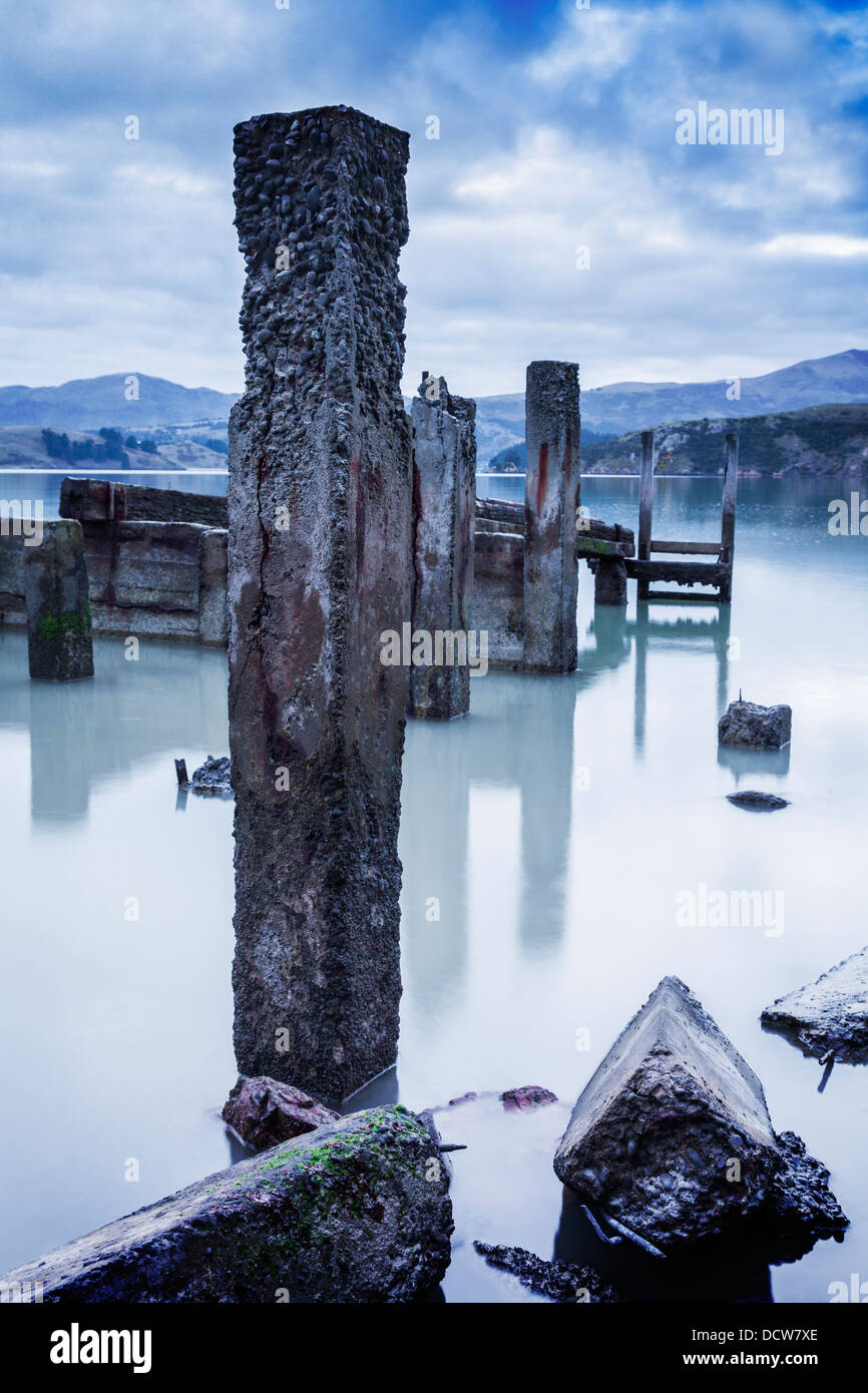 Old concrete jetty posts revealed at low water, with very smooth water ...