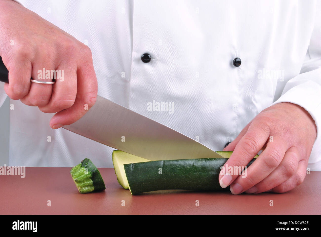 female chef cut one zucchini with a kitchen knife Stock Photo - Alamy