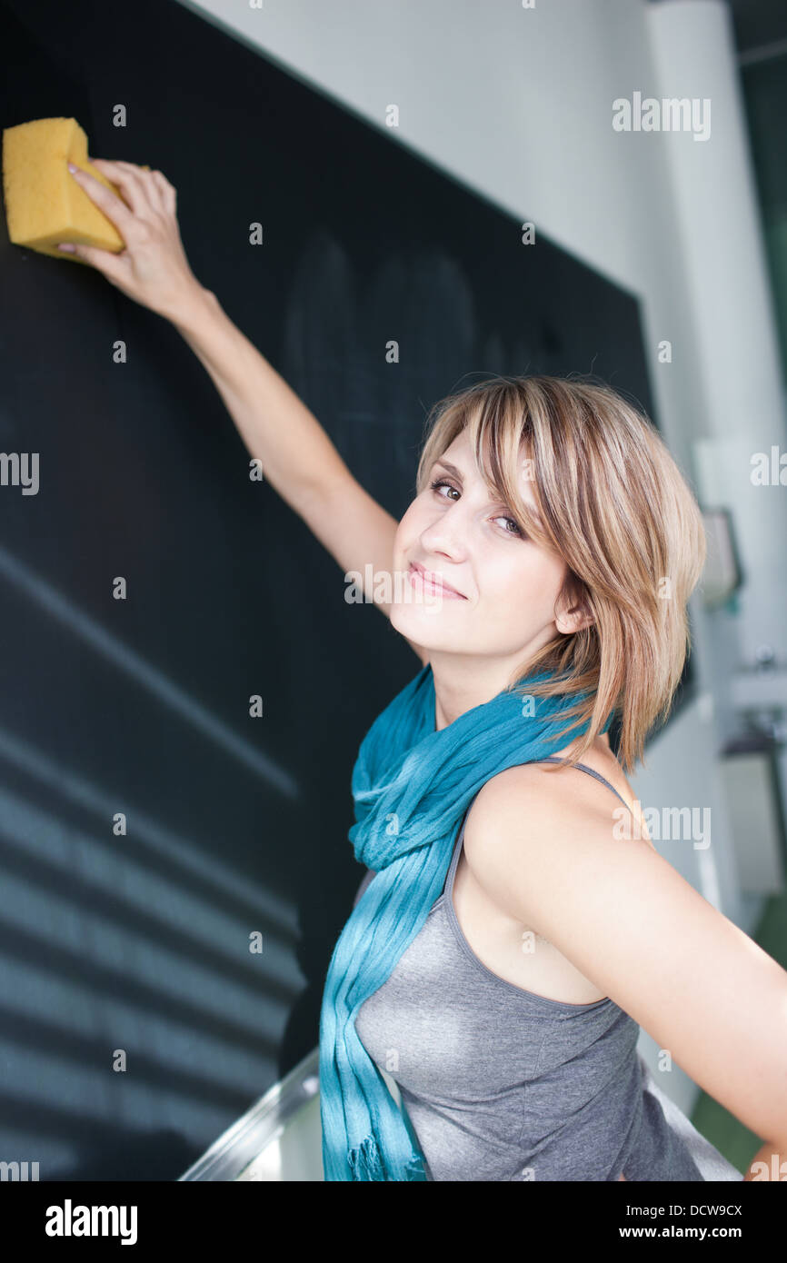 pretty college student erasing the chalkboard/blackboard Stock Photo ...