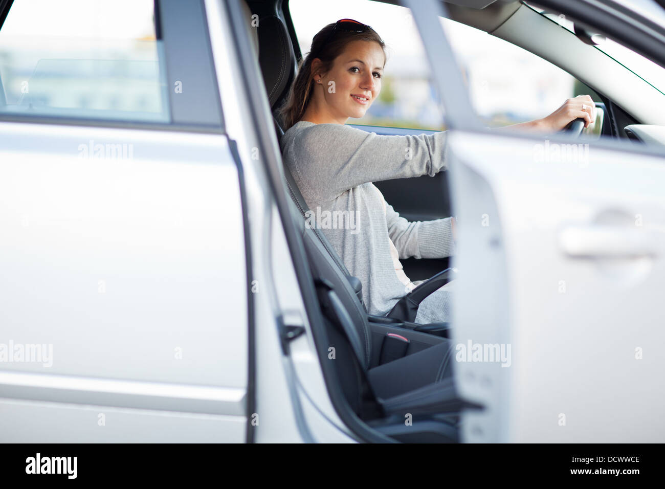 Pretty young woman driving her new car Stock Photo - Alamy