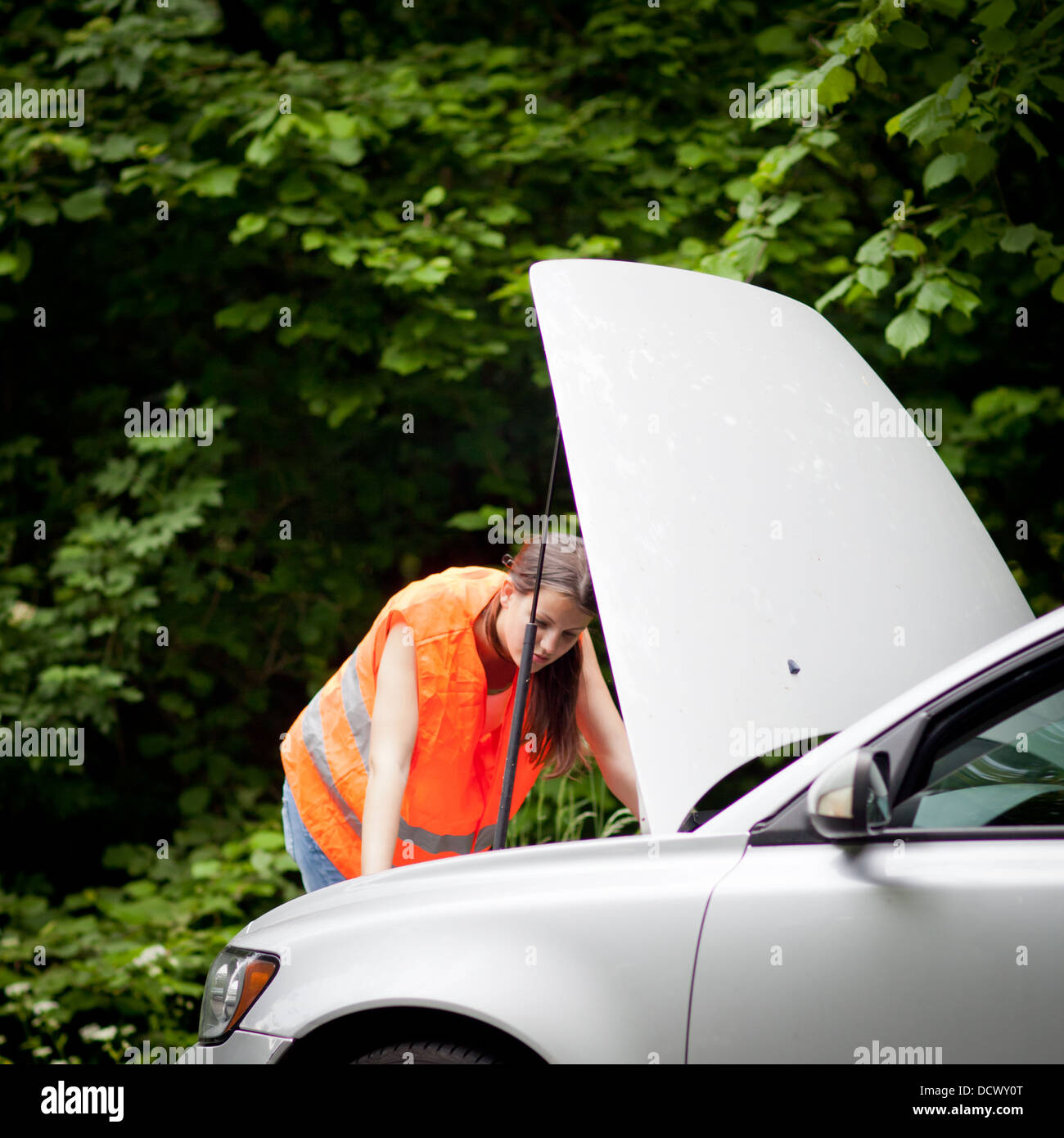 Young female driver wearing a high visibility vest, calling the Stock ...