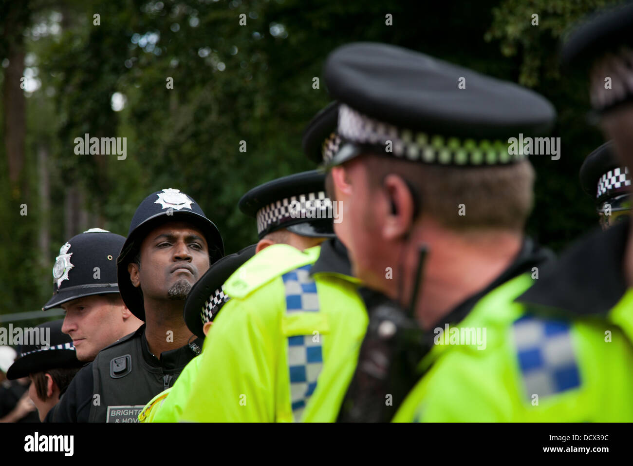 A black officer looks across his colleagues. Police lines protecting ...