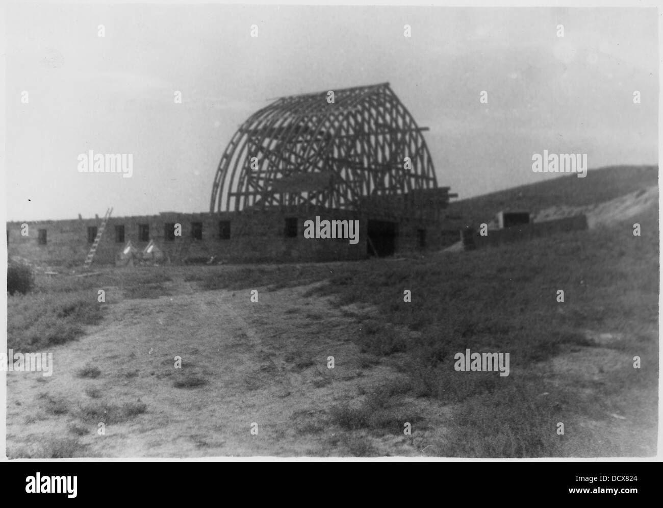 The framework of a barn roof structure is partially completed in this ...