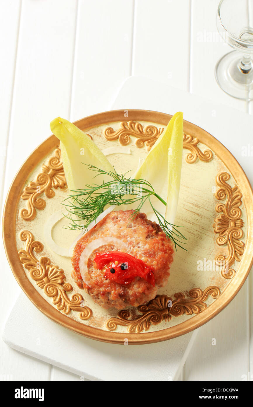 Pan fried burger garnished with endive leaves Stock Photo - Alamy
