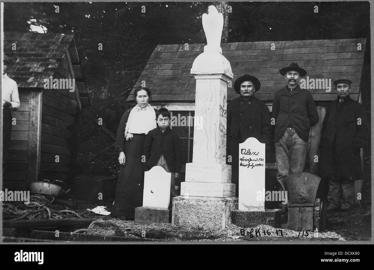 A group of people gathered at a cemetery around the grave of Alex, born ...