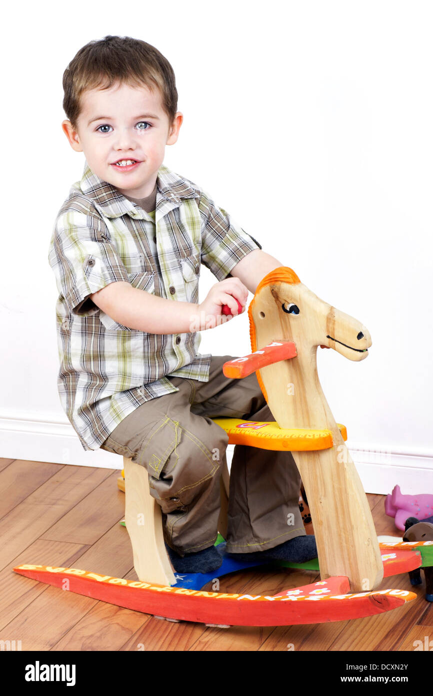 Little boy riding a rocking horse Stock Photo - Alamy
