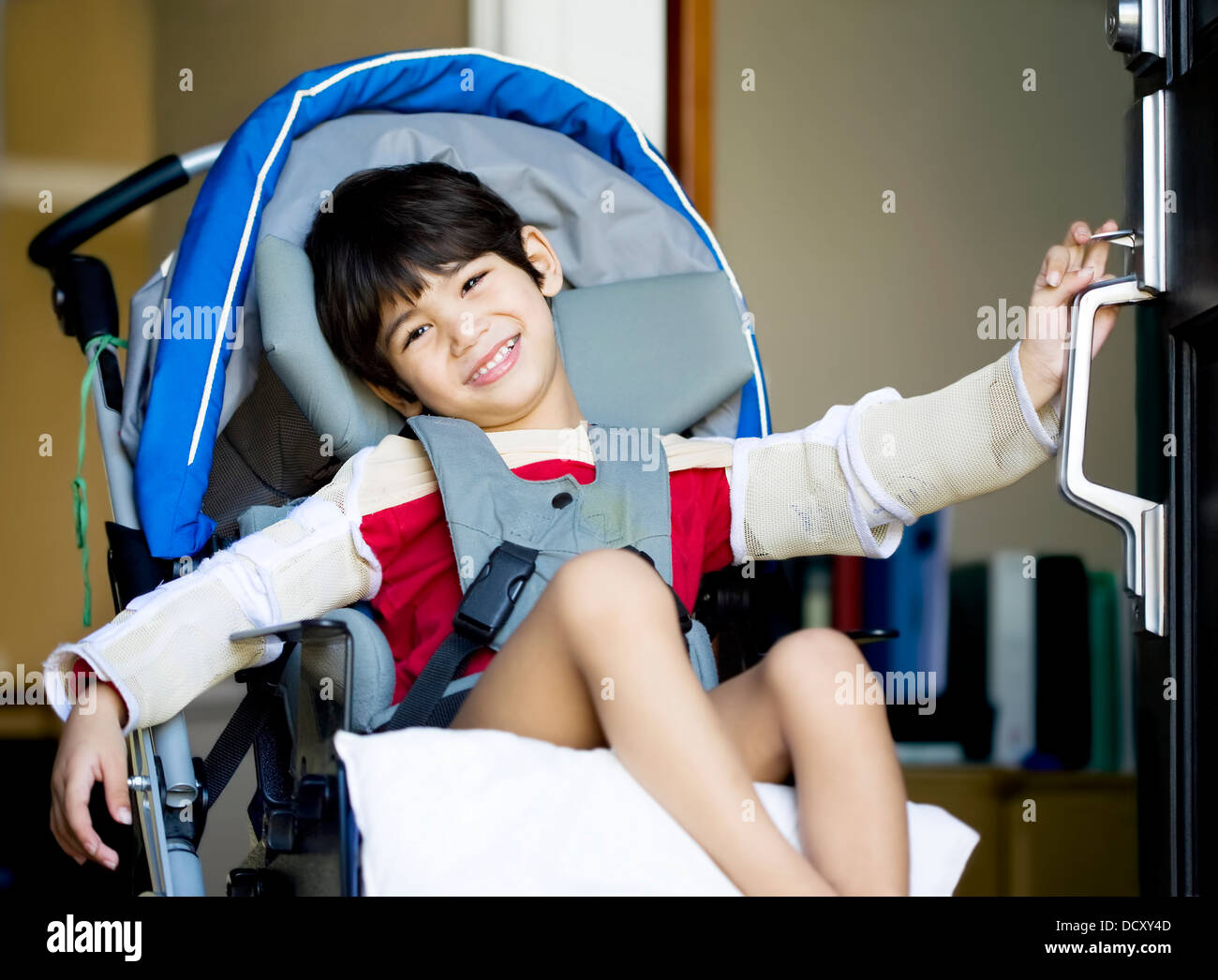 Handsome four year old disabled boy in wheelchair opening front Stock ...