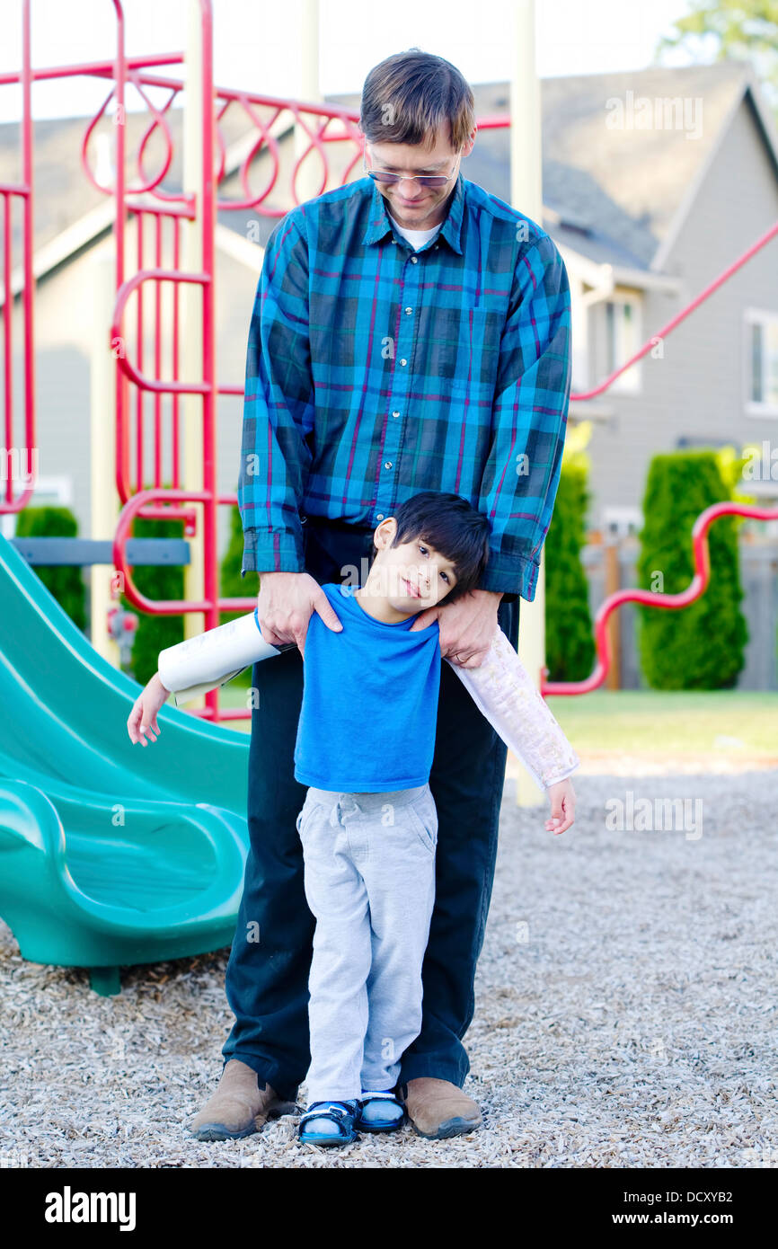 Father helping disabled son at playground Stock Photo - Alamy