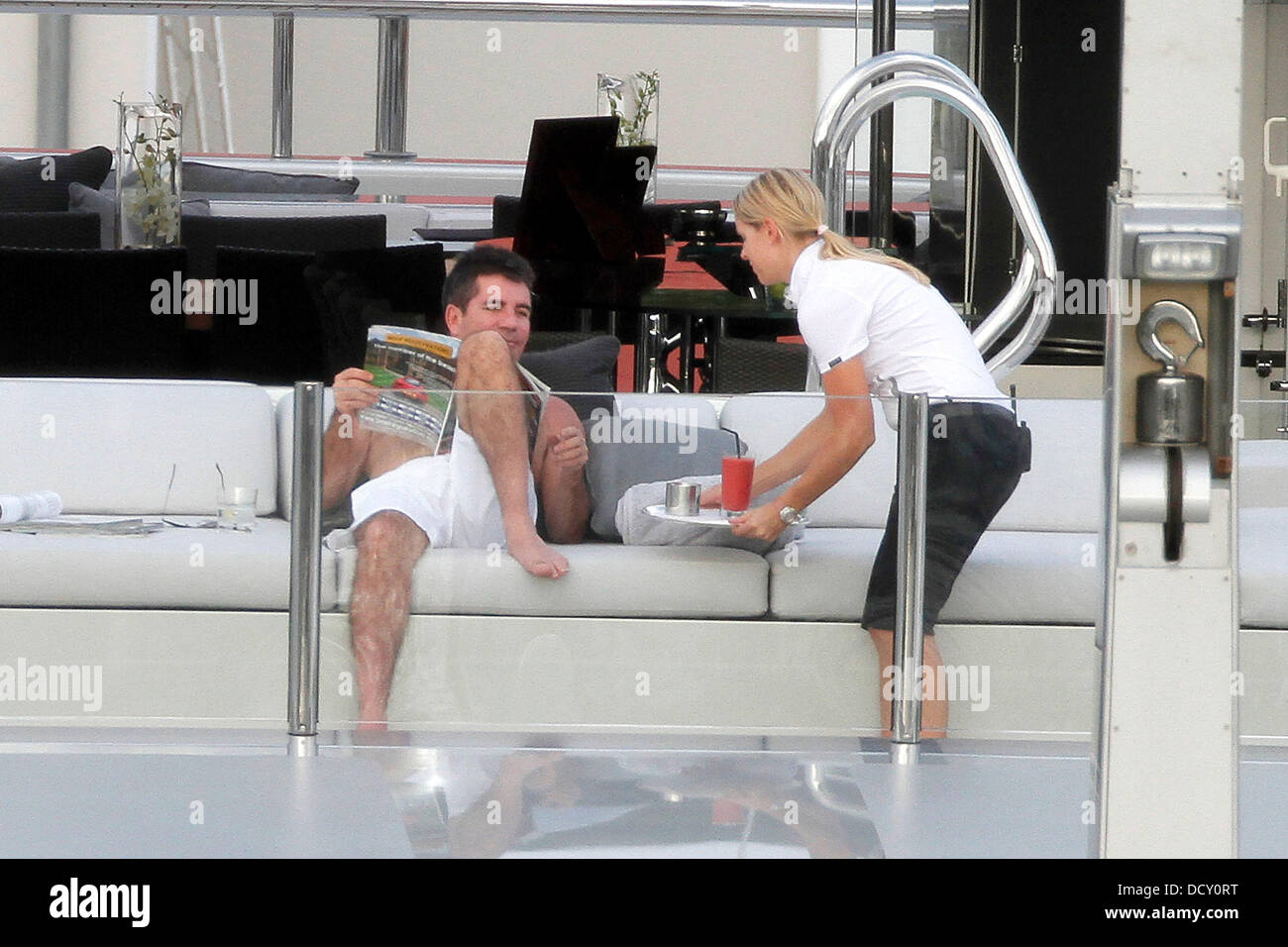 Simon Cowell orders a drink as he relaxes onboard the luxury super ...
