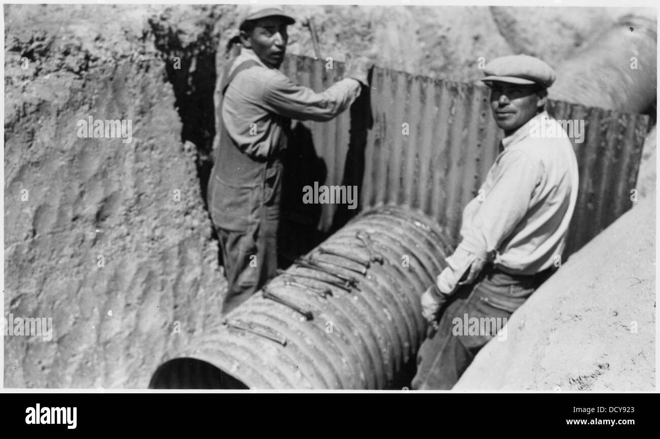 A construction worker installs a drainage pipe as part of a civil ...