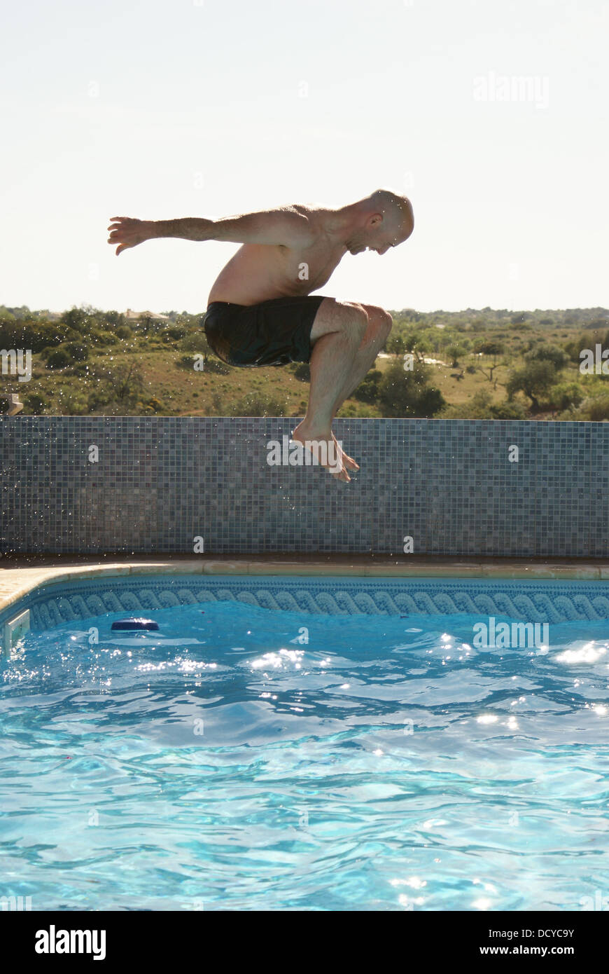Man jumping into swimming pool Stock Photo - Alamy