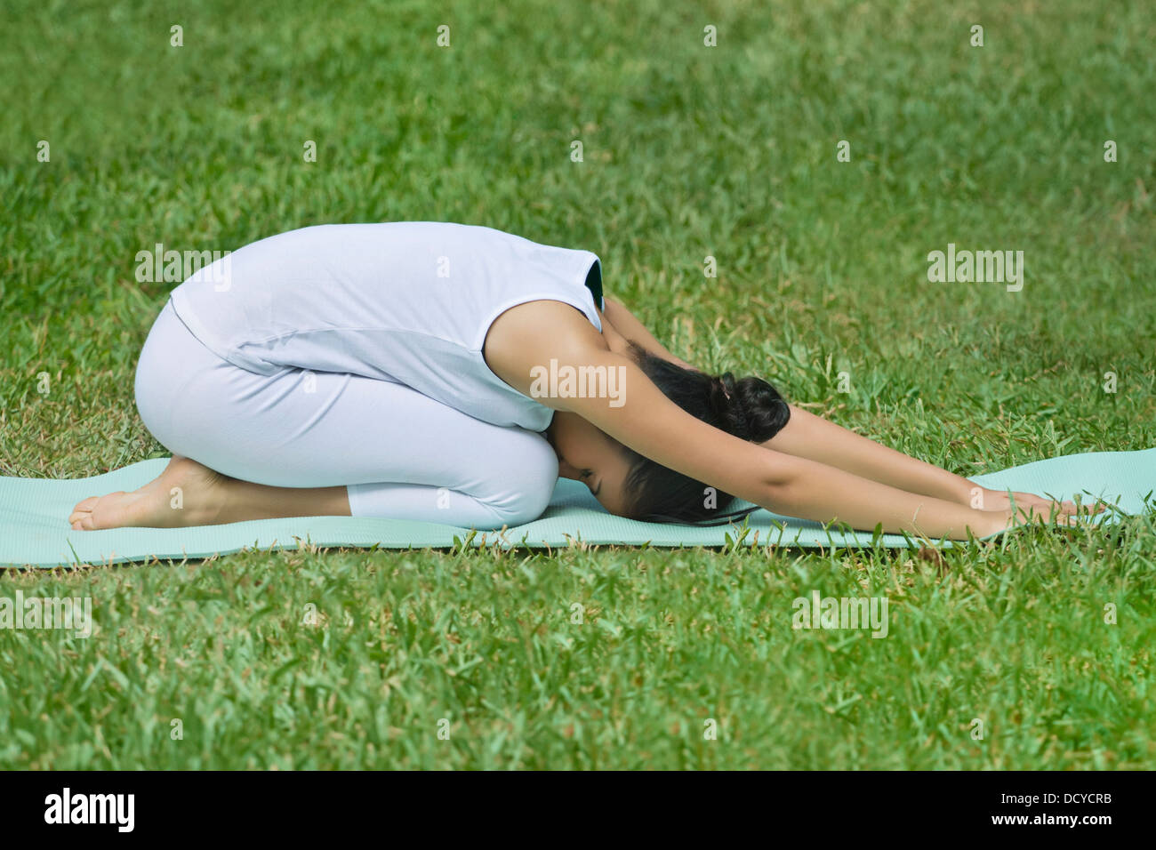 Young woman doing yoga on a lawn Stock Photo - Alamy