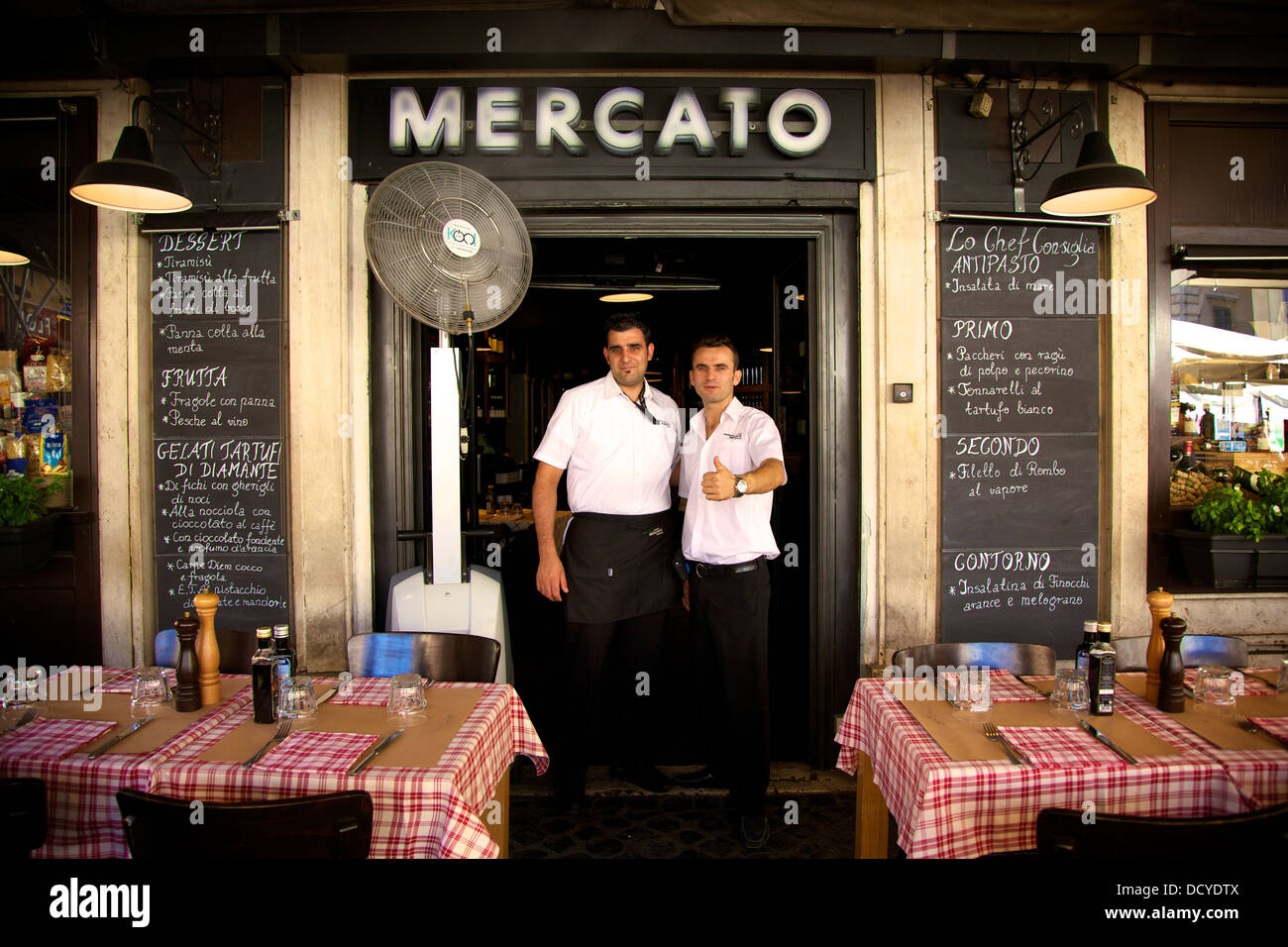 Cafe tables and chairs outside a quaint stone building in Tuscany ...