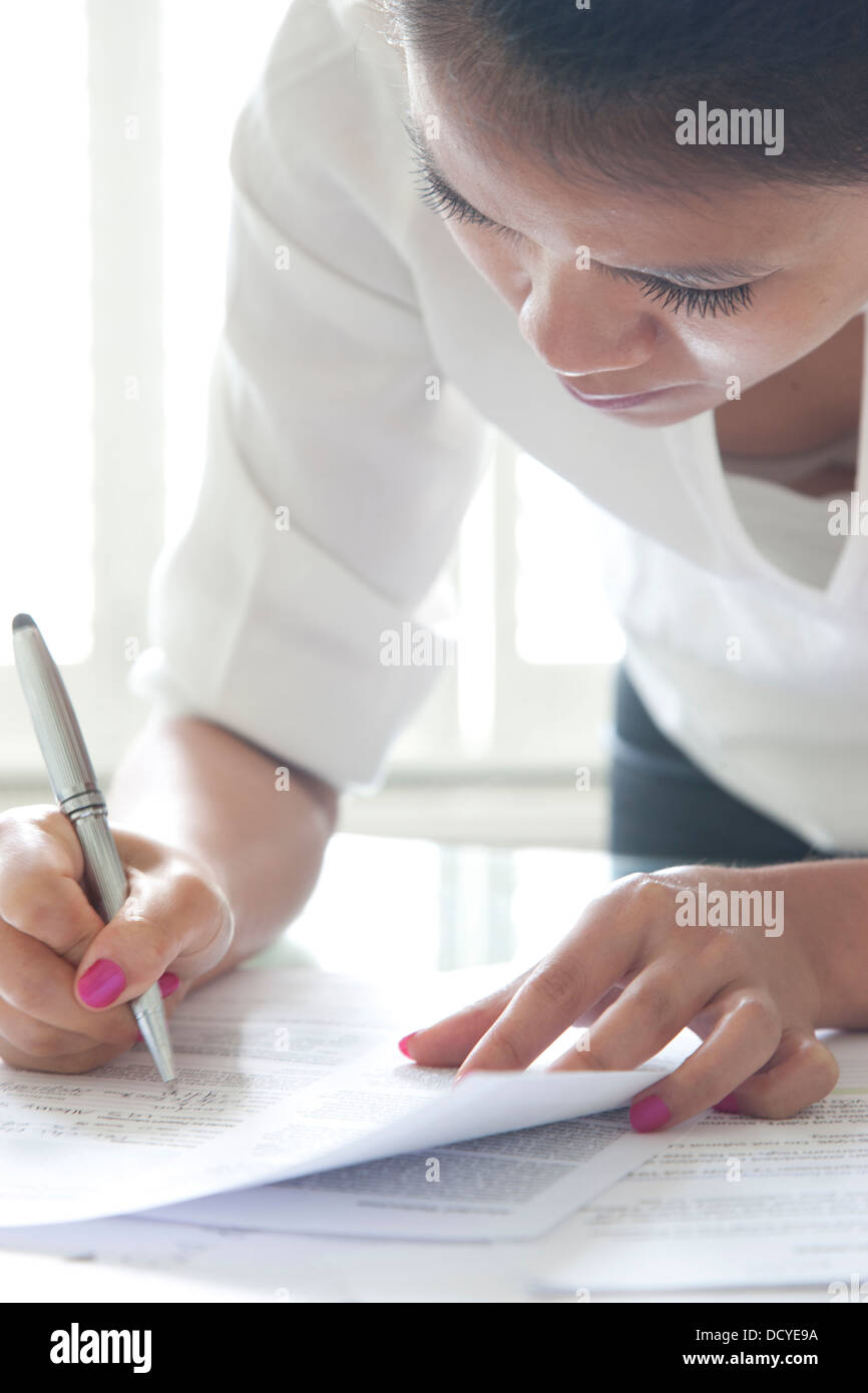 Professional woman signing document at desk hi-res stock photography ...