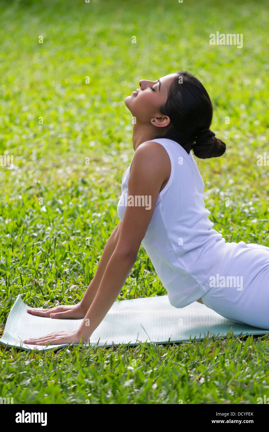 Young woman doing yoga on a lawn Stock Photo - Alamy